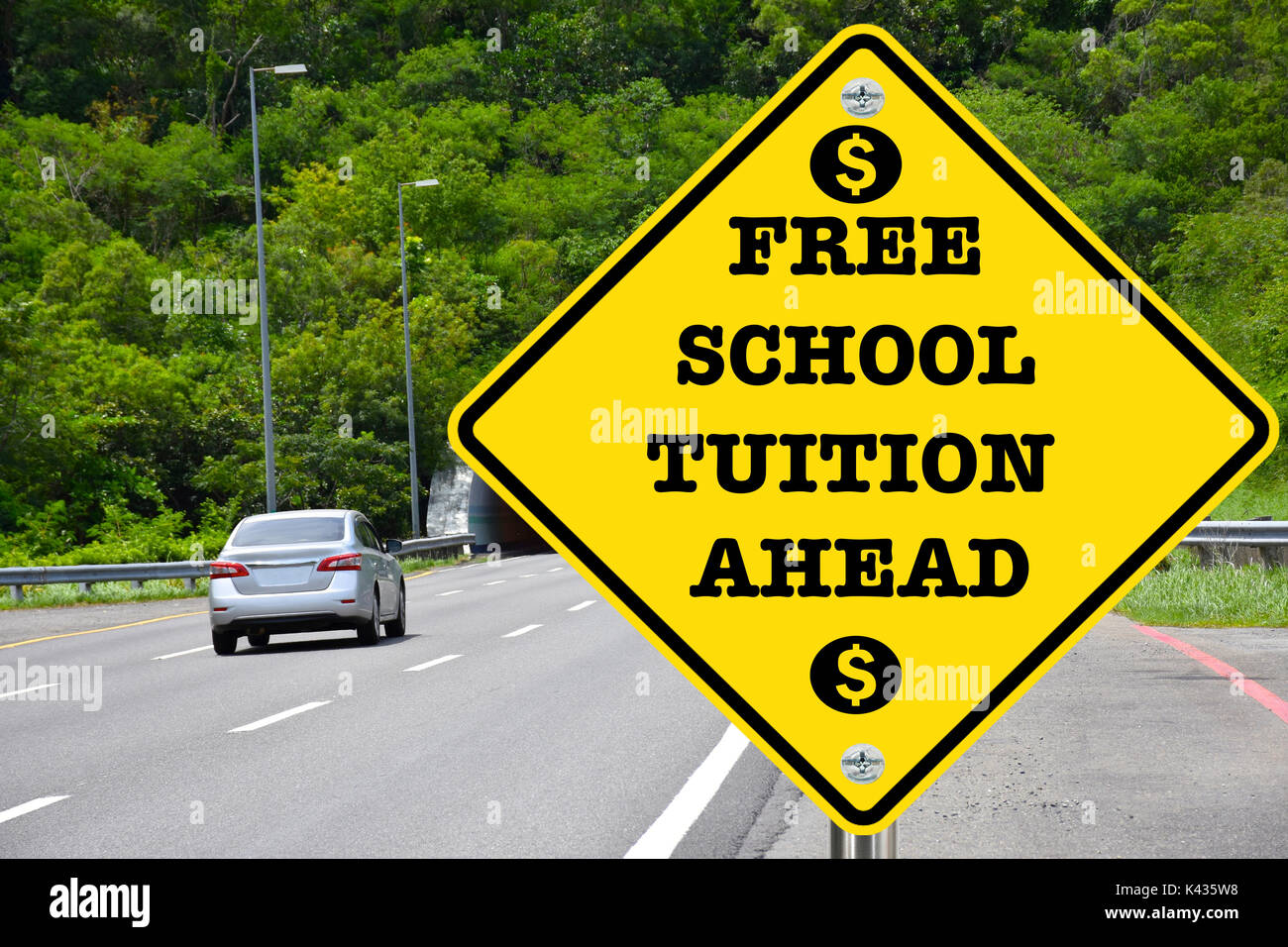 Free school tuition ahead, yellow warning road sign Stock Photo - Alamy