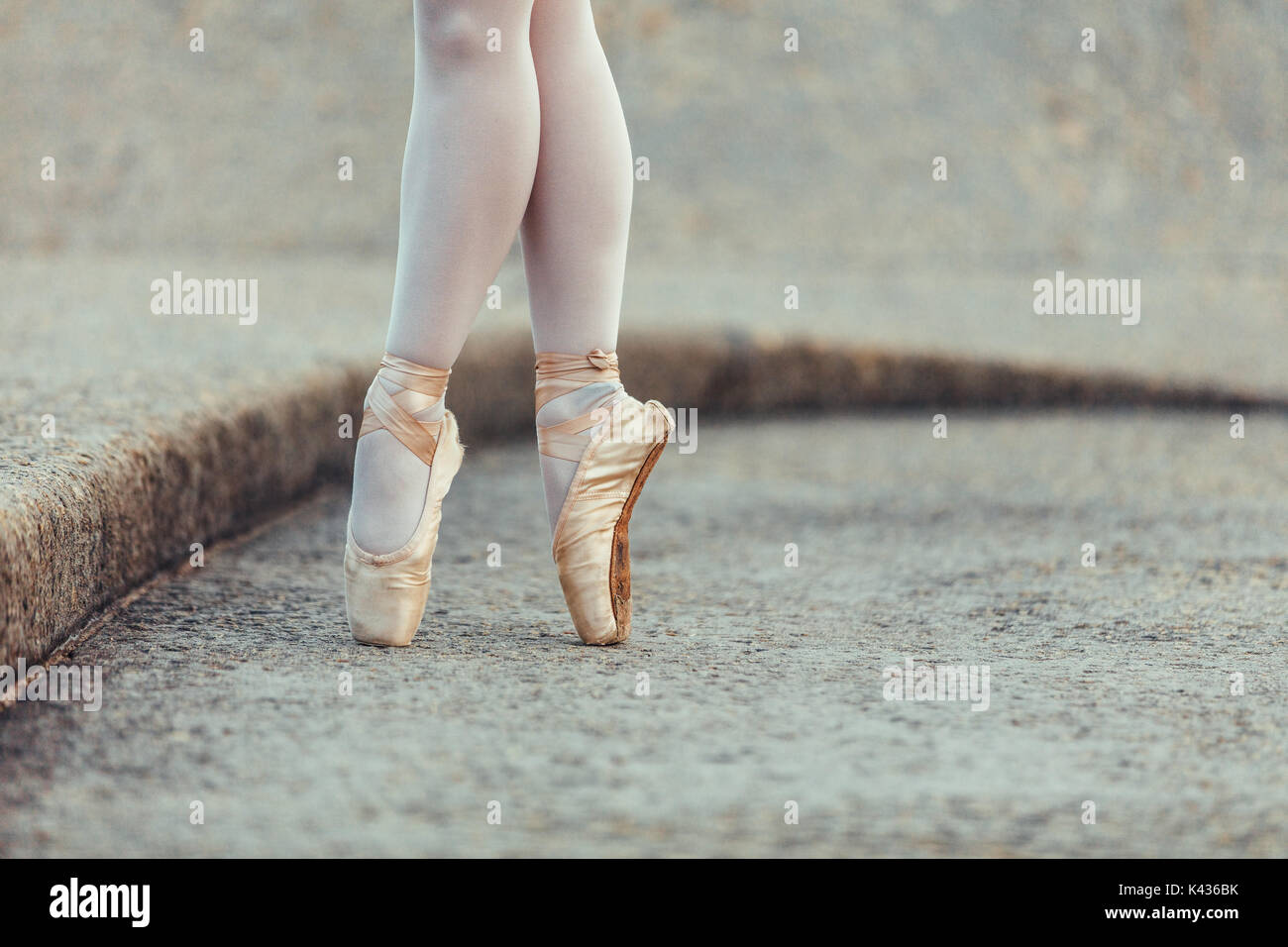 Closeup shot of legs of a female ballet dancer standing on her toes ...