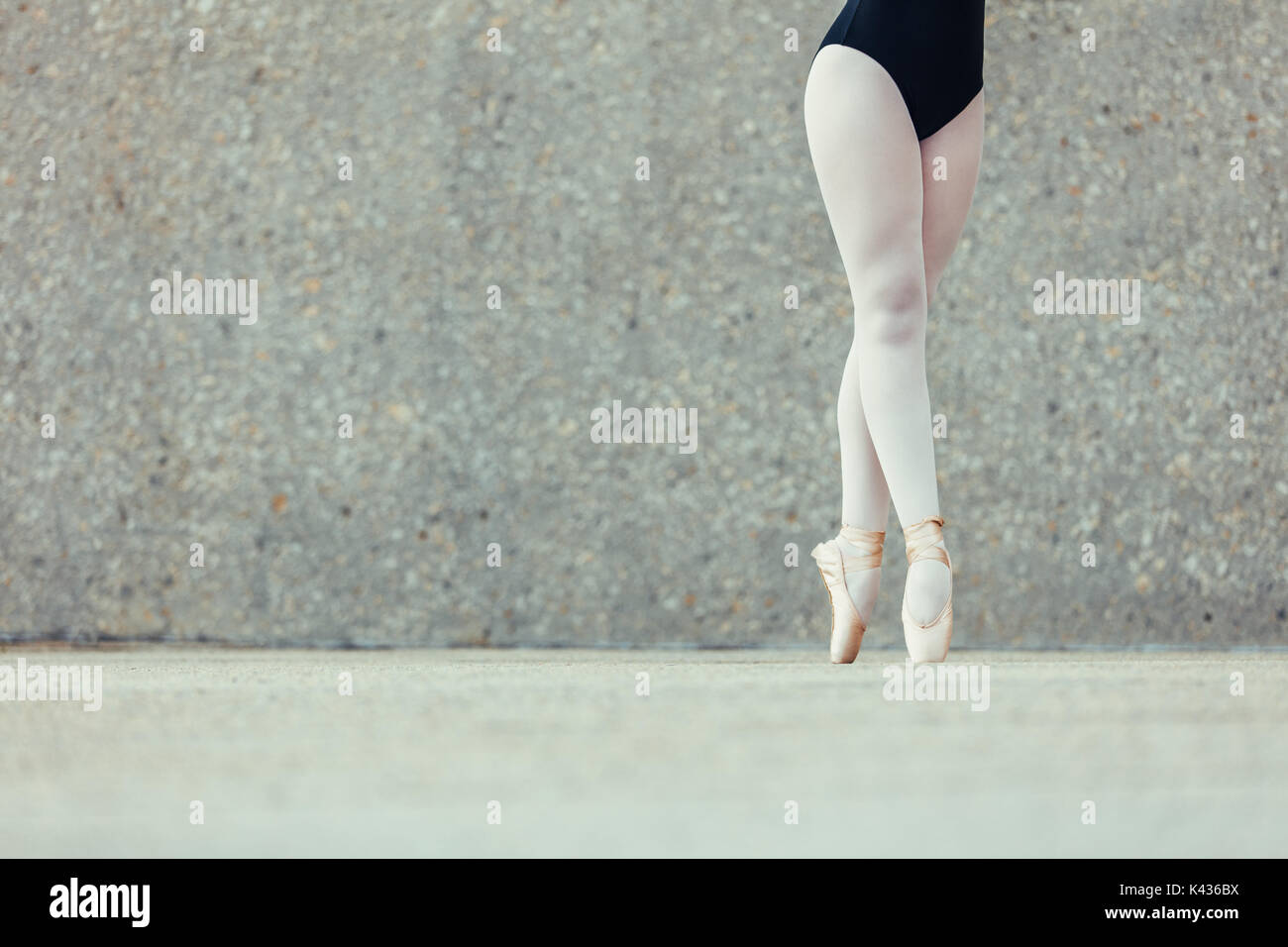 Closeup shot of legs of a female ballet dancer standing on her toes ...