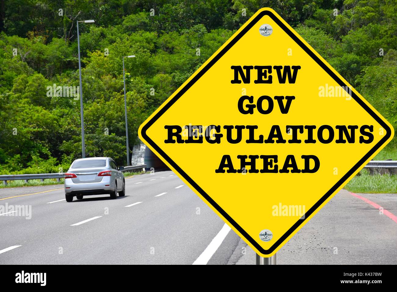 New gov regulations ahead, yellow warning road sign Stock Photo - Alamy
