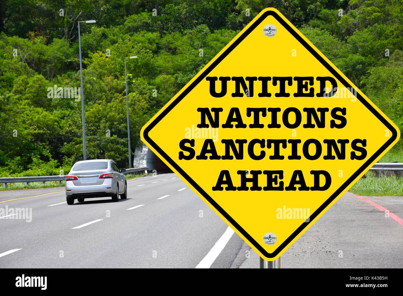 United Nations Sanctions Ahead warning yellow road sign Stock Photo - Alamy