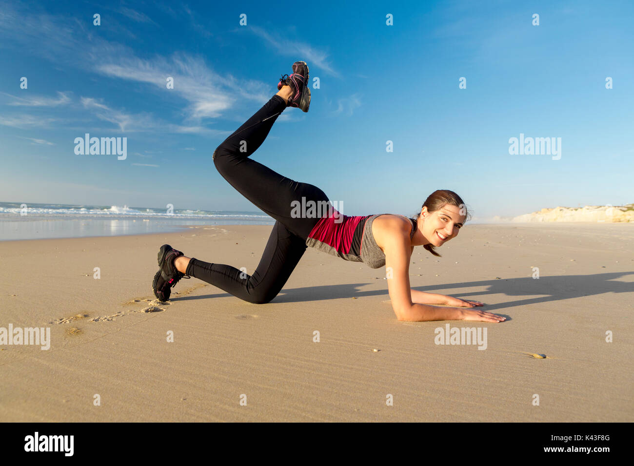 Shoot of a beautiful woman exercising herself in the beach Stock Photo ...