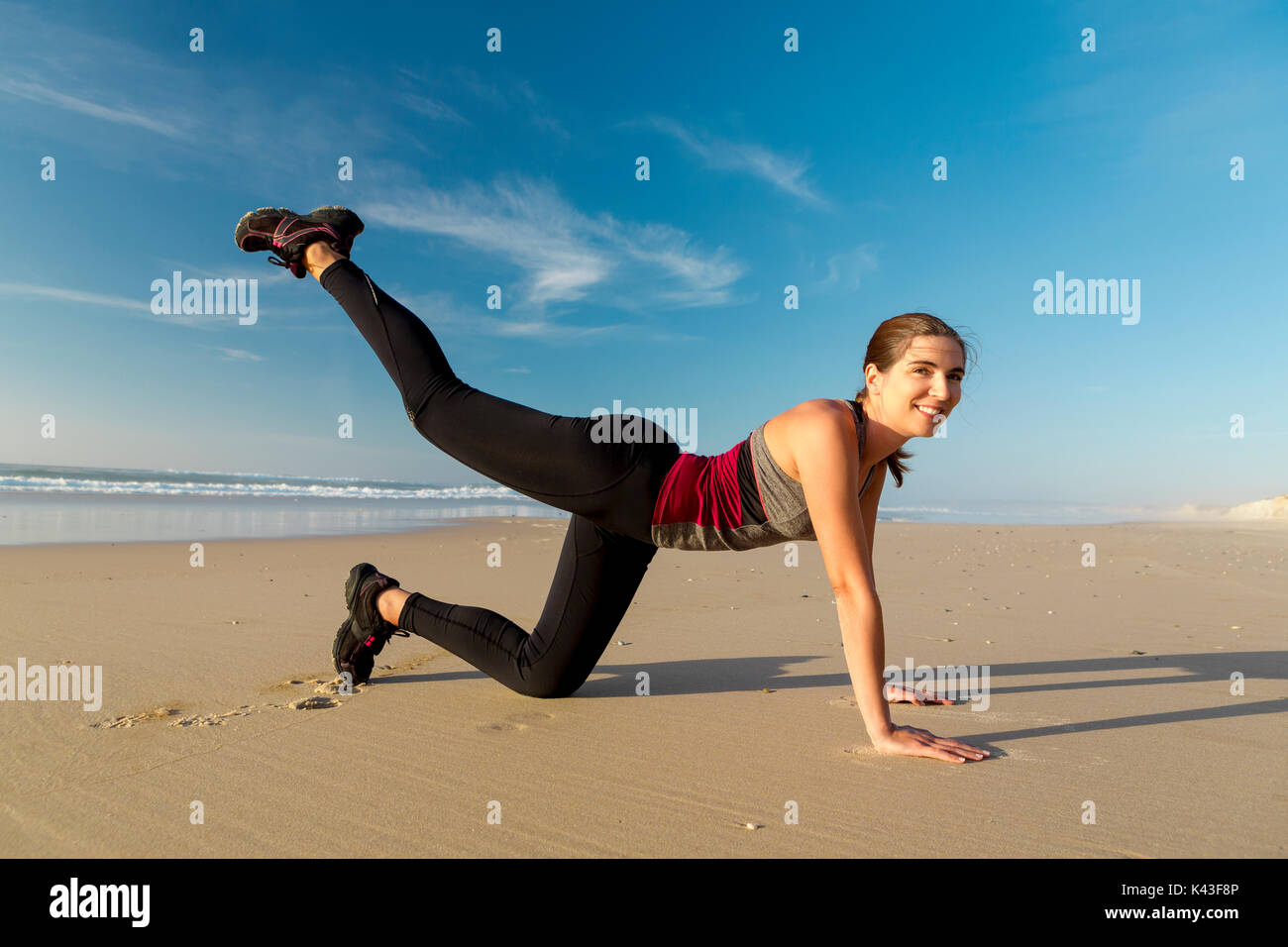 Shoot of a beautiful woman exercising herself in the beach Stock Photo ...