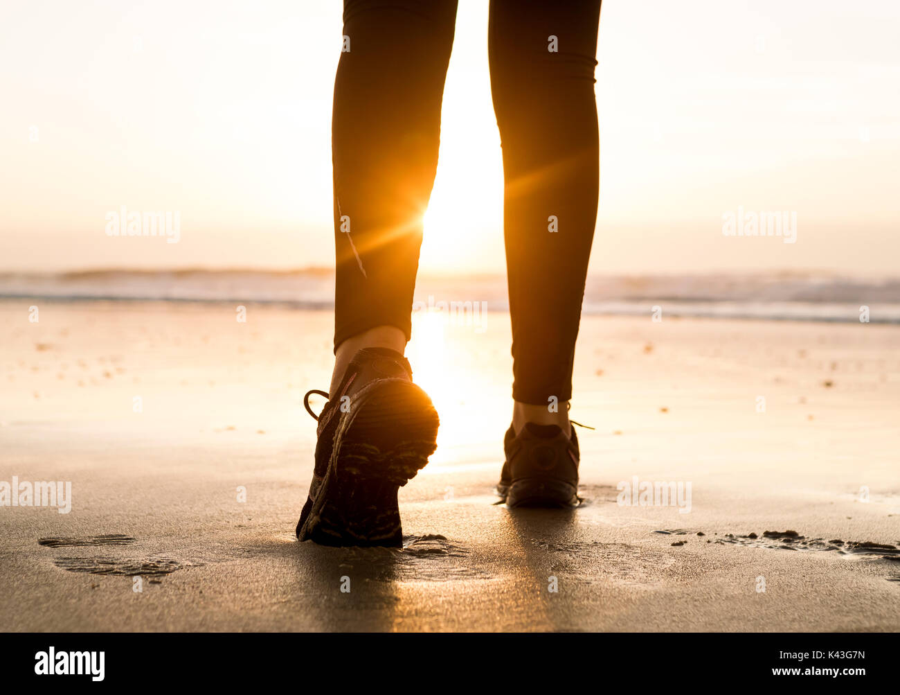 Female legs walking at the beach in direction to the sun Stock Photo ...
