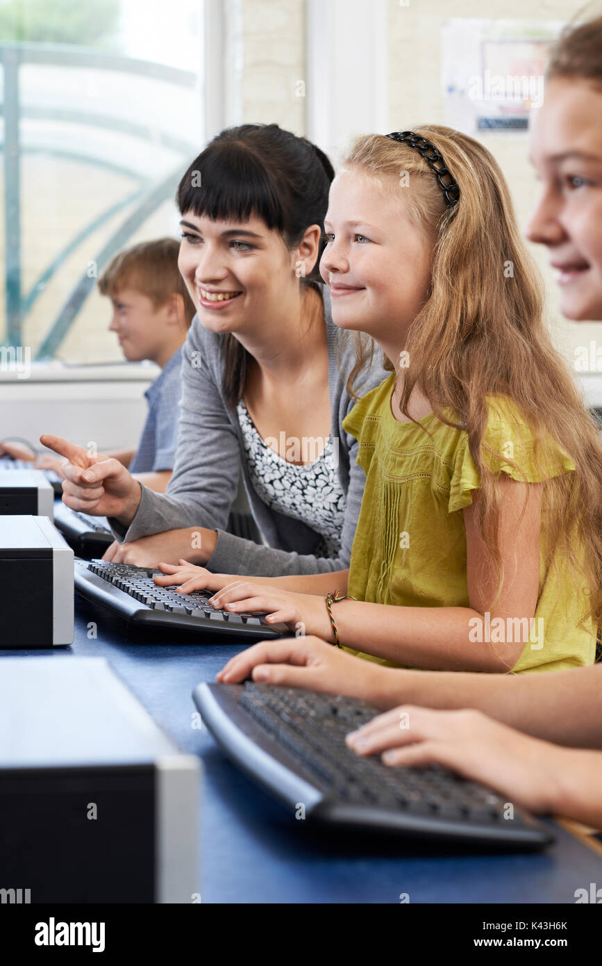 Female Elementary Pupil In Computer Class With Teacher Stock Photo - Alamy