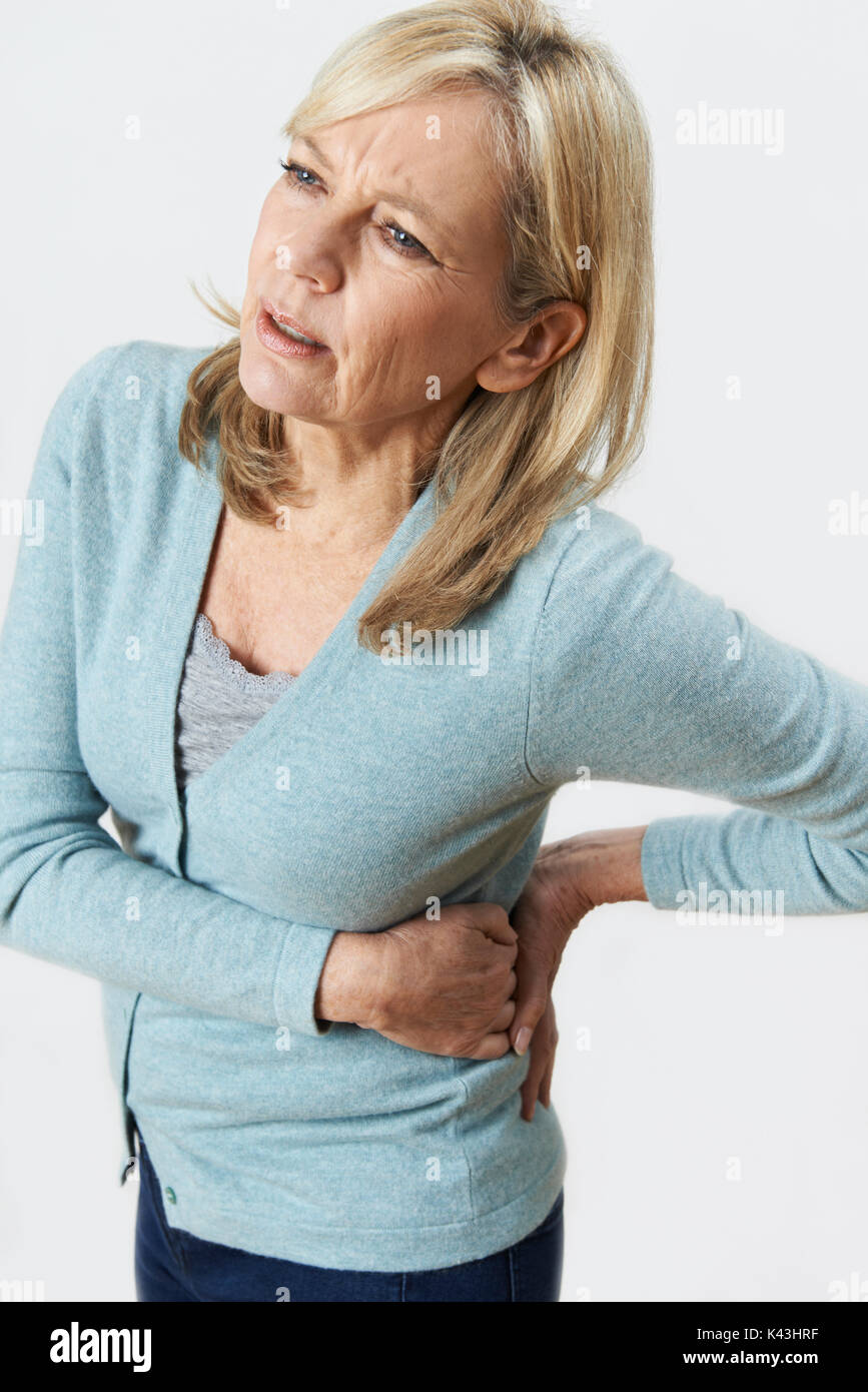Studio Shot Of Mature Woman Suffering With Kidney Pain Stock Photo - Alamy