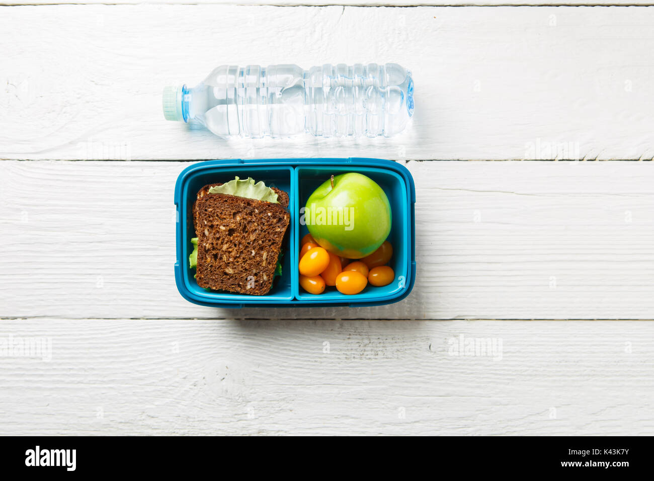Photo of fitness snack in container, bottle of water on empty white ...