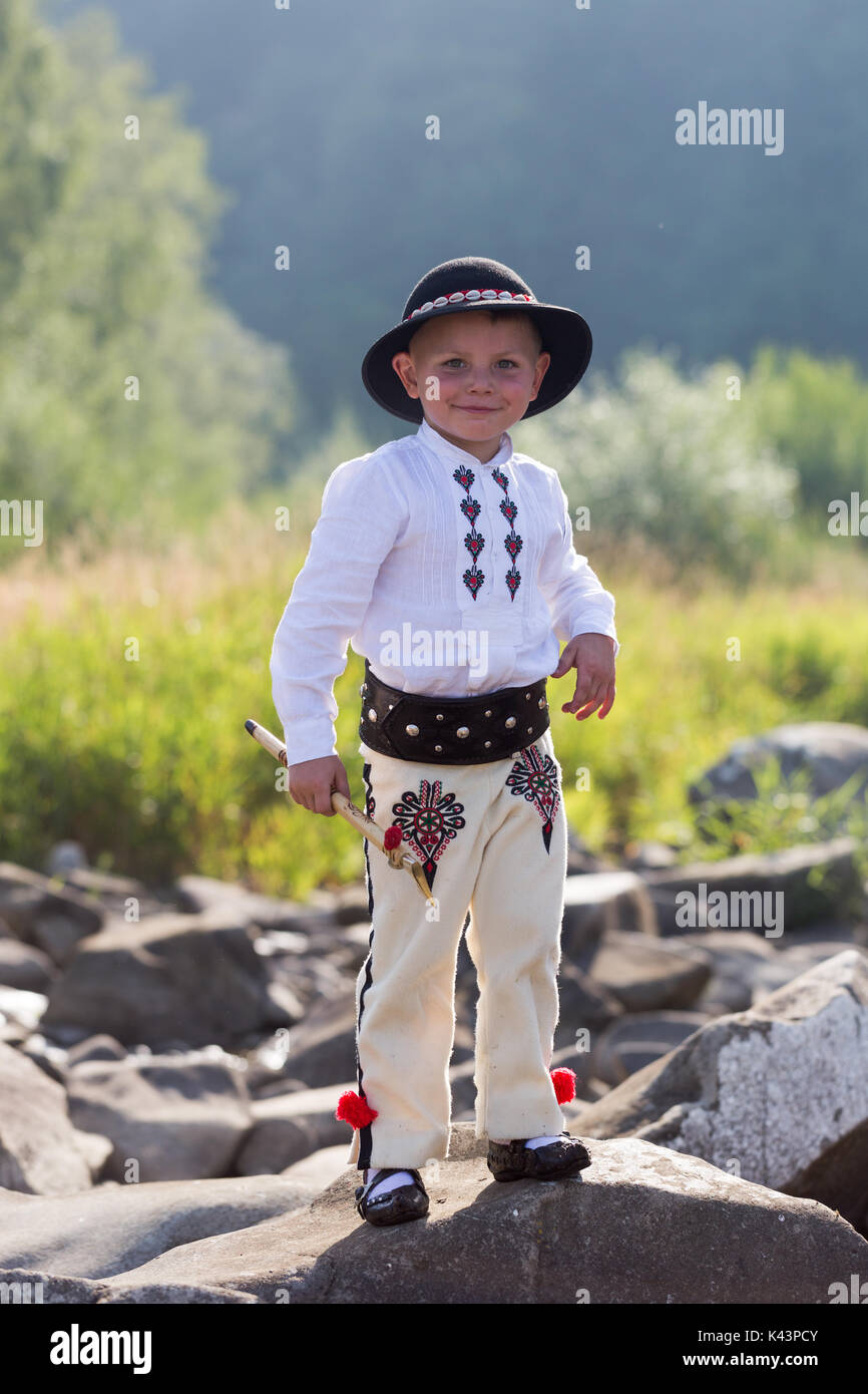 Smiling child boy in traditinal Polish mountain outfit and black hat ...