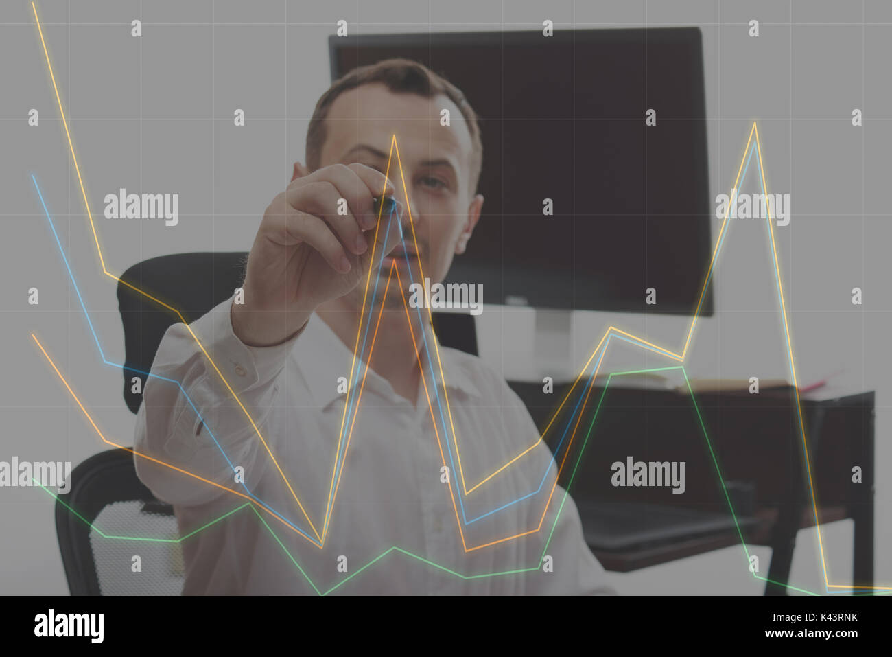 Man pointing on peak of graphic. Young man drawing colorful finance ...