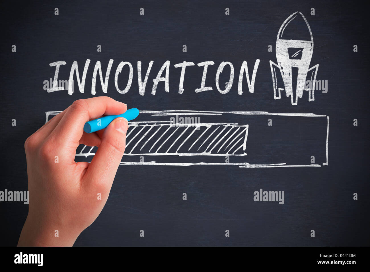 Hand holding blue chalk against black background Stock Photo - Alamy