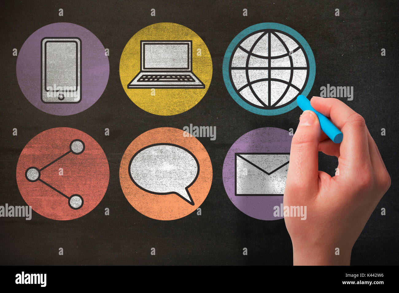 Hand holding blue chalk against black Stock Photo - Alamy