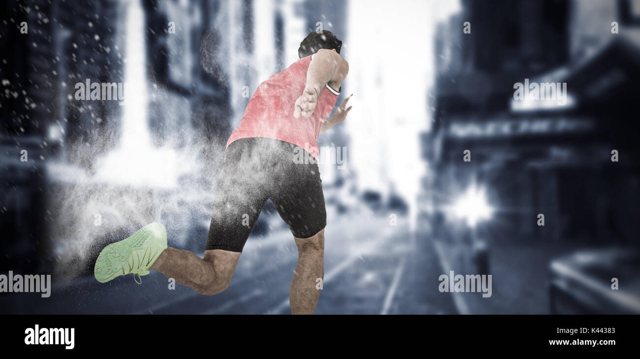Male athlete running from starting blocks against white dust powder ...