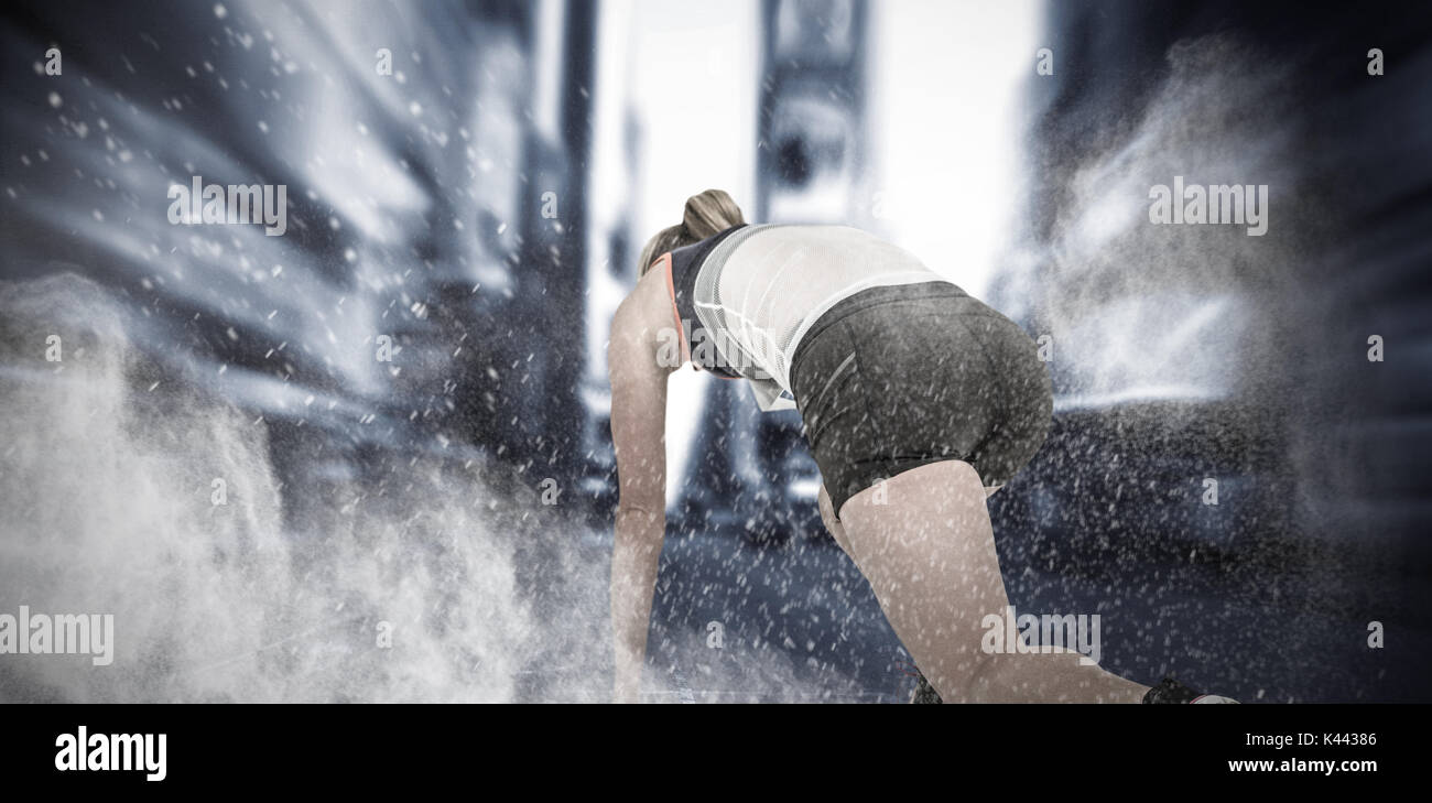 Female athlete in position ready to run against splashing of dust ...