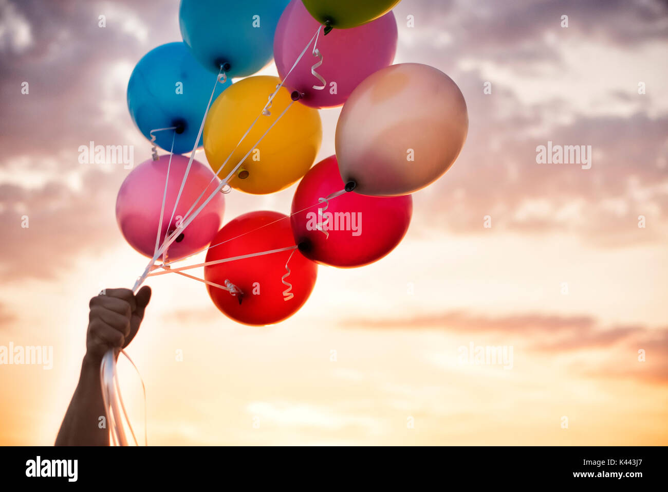 Man Hand Holding Colorful Balloons And A Beautiful Sunset. Birthday ...