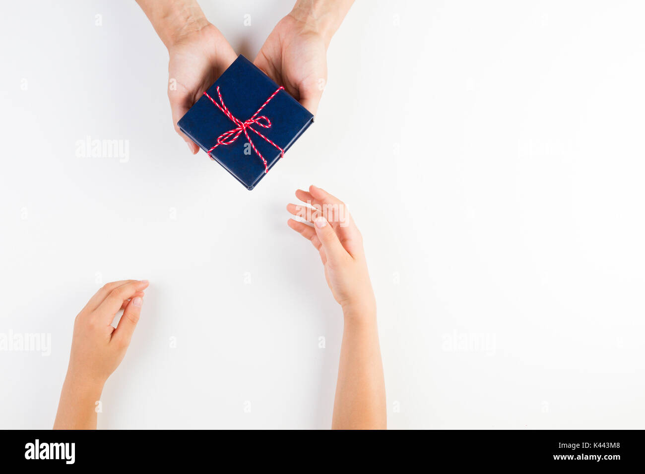 Child and adult hands giving and receiving a present Stock Photo - Alamy