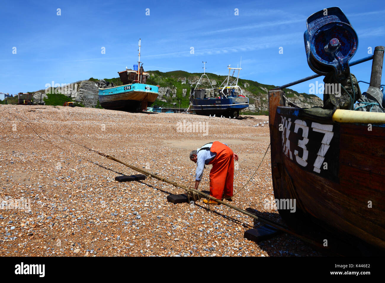 Fisherman putting wooden block in front of fishing boat to protect keel ...