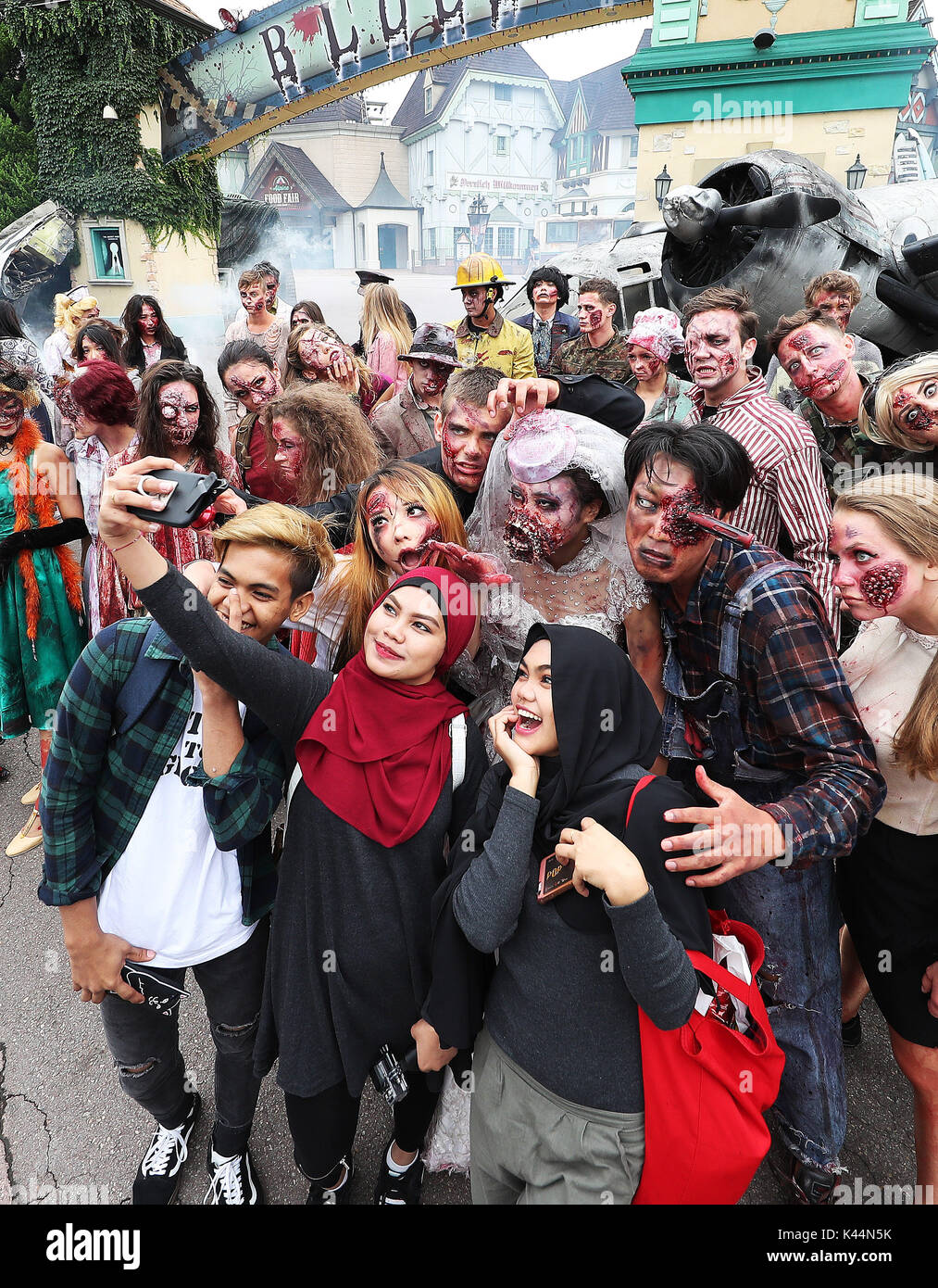 Visitors pose with zombies at amusement park Visitors pose for a photo ...
