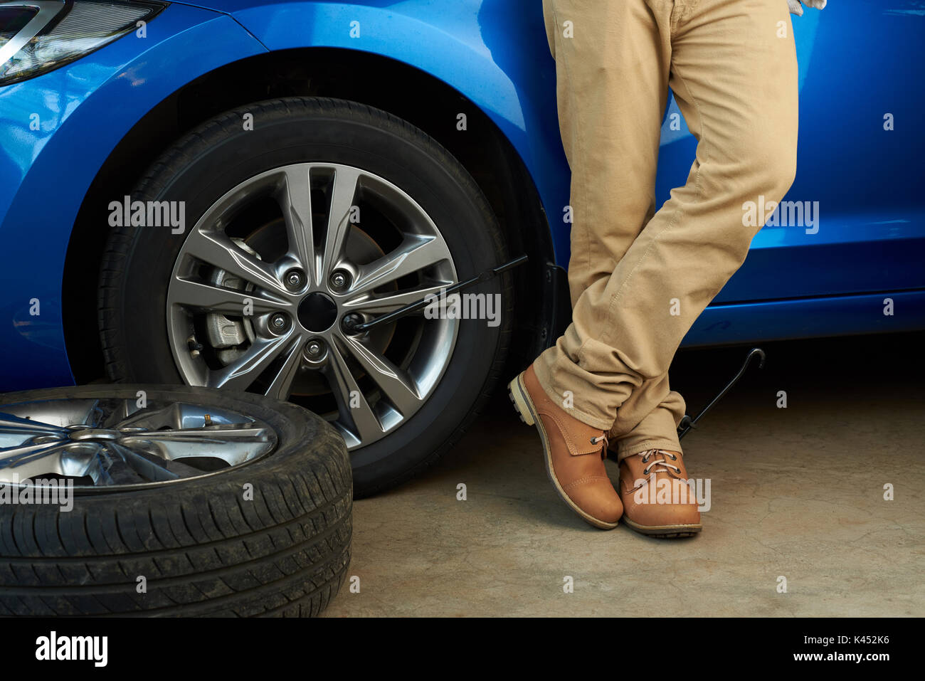 Man changed damaged car wheel. Casual guy changing wheel of car Stock ...