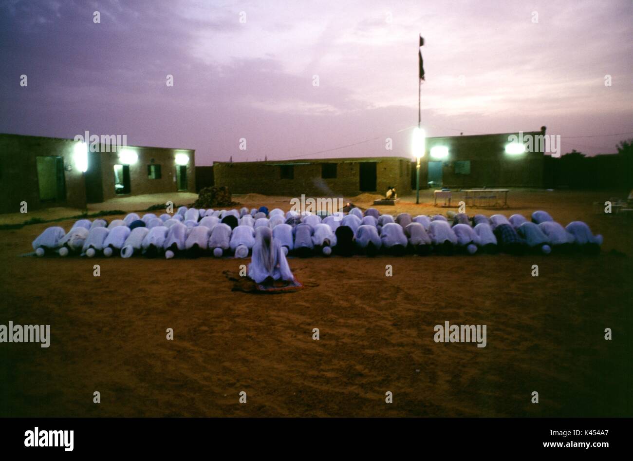 Devout Sudanese muslims during outdoor evening prayers under the open ...