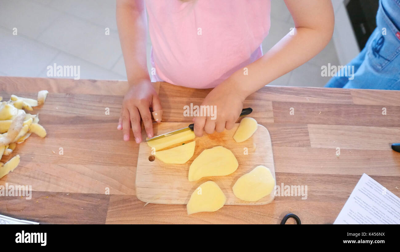 Child cuts potatoes into pieces with a sharp knife Stock Photo - Alamy