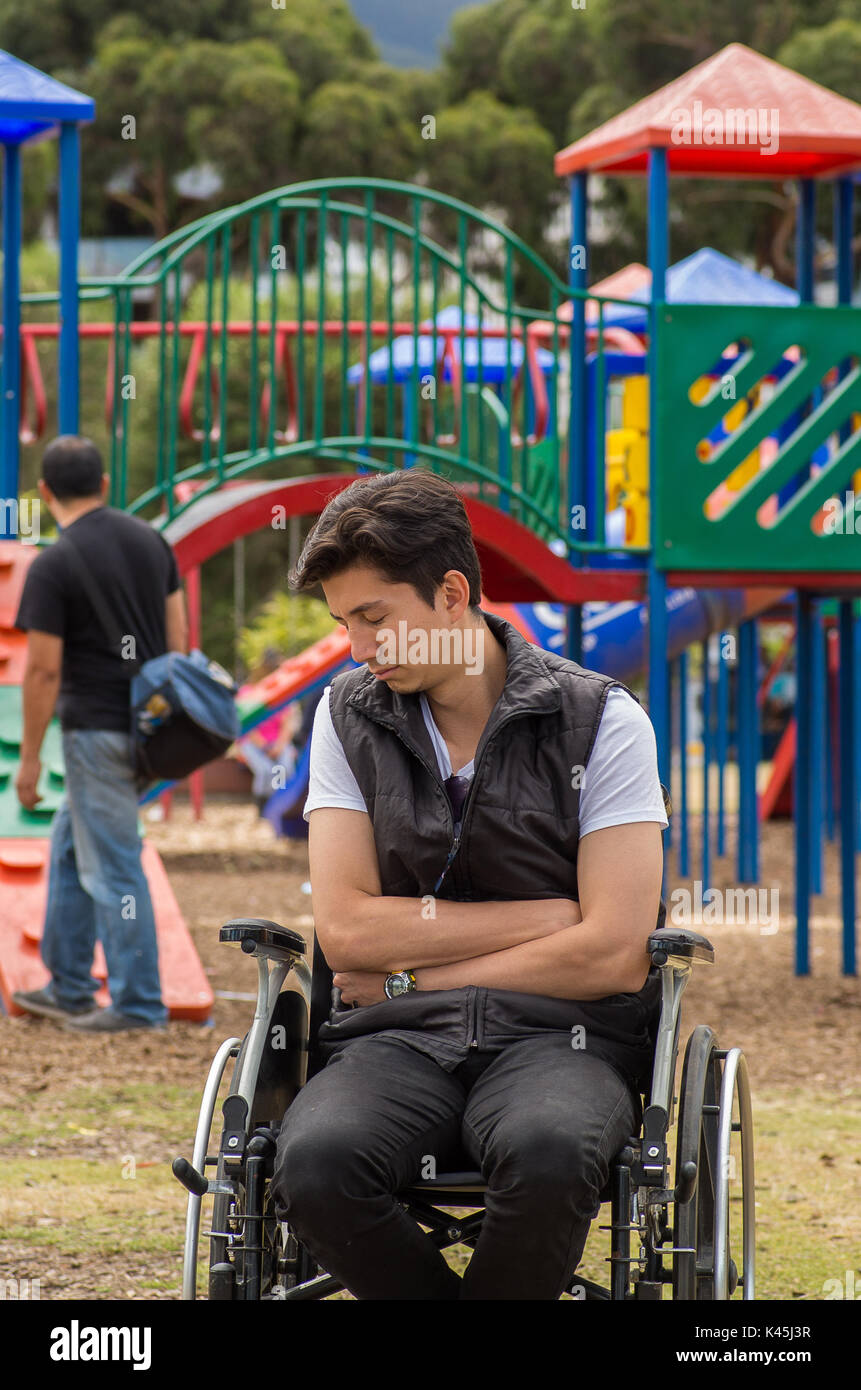 Close up of a handsome young disabled man in wheelchair, crossing his ...
