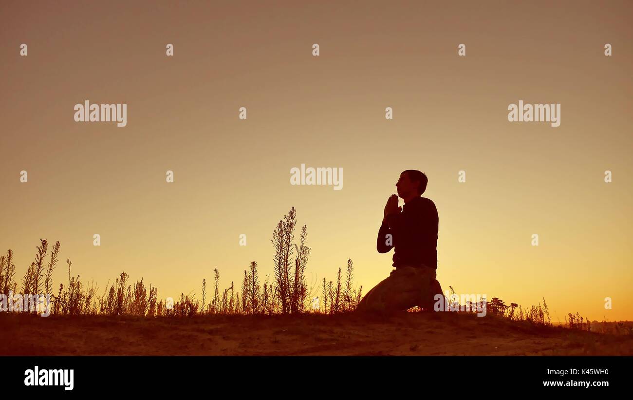 Silhouette illustration of a man praying outside at beautiful landscape ...