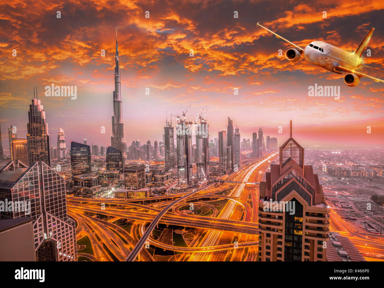 Airplane is flying over Dubai against colorful sunset in United Arab ...