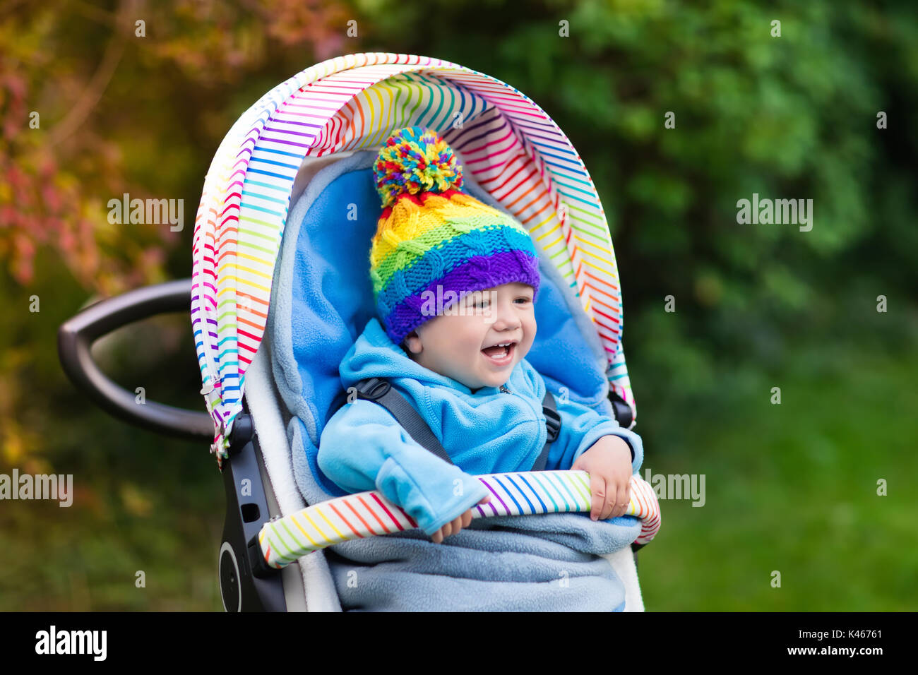 Baby in stroller on a walk in autumn park. Adorable little boy with ...