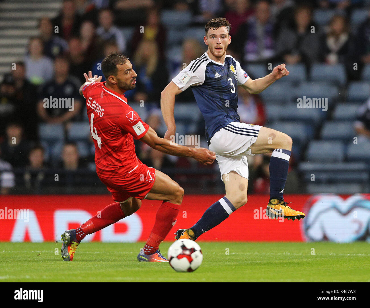 Malta's Steve Borg (left) and Scotland's Andrew Robertson in action ...
