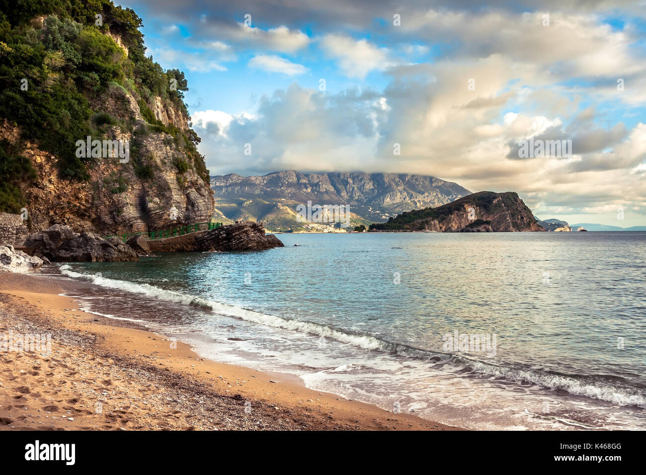 Scenic beach with cliff and rocks surrounded with vibrant transparent ...
