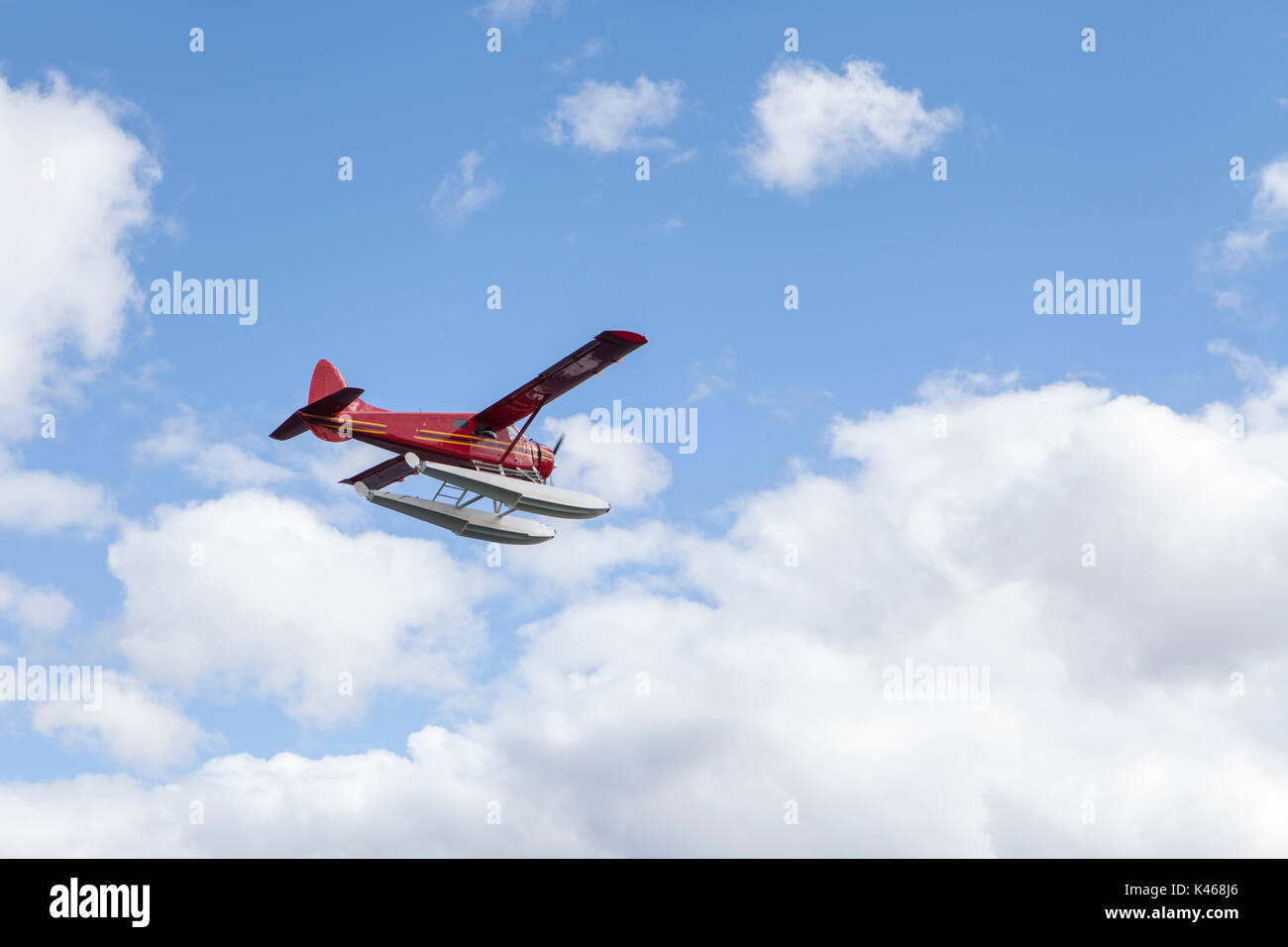 Small float plane in blue sky with puffy clouds Stock Photo - Alamy