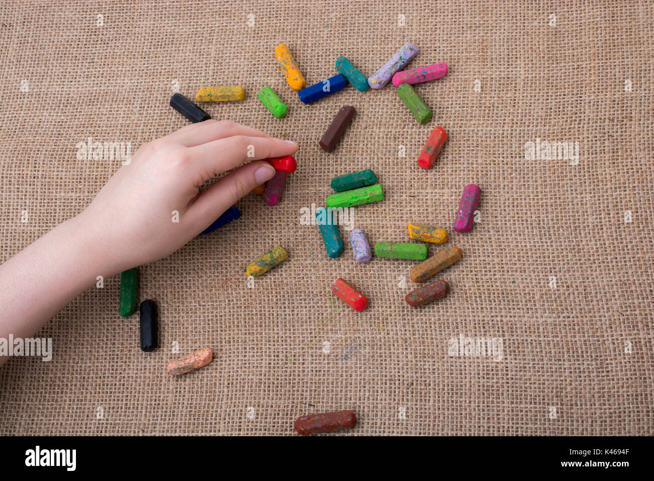 Used color crayons and a hand holding one Stock Photo - Alamy