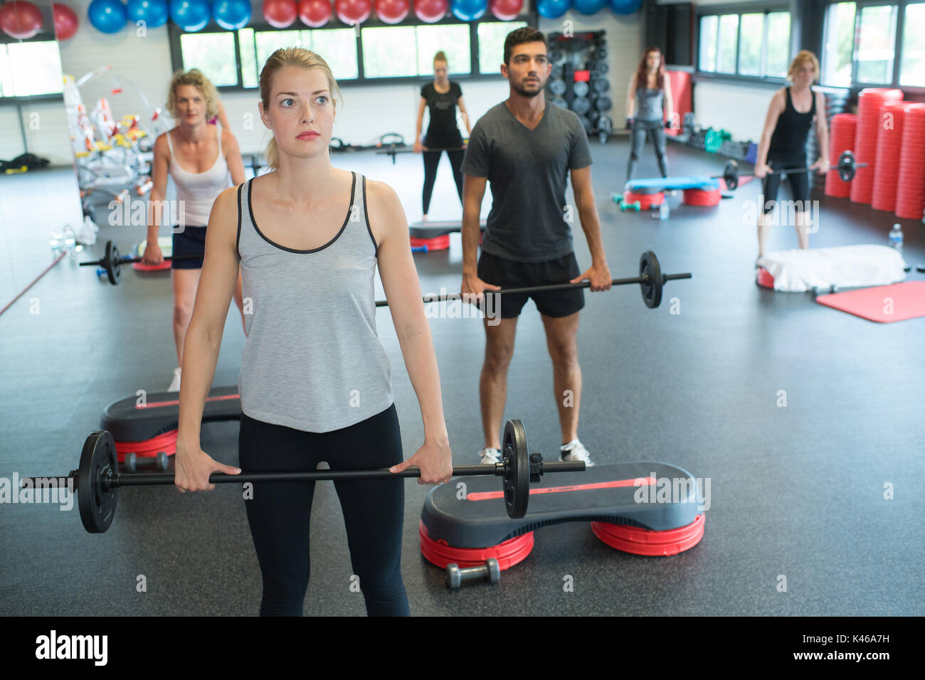group of people exercising with barbell bars in gym Stock Photo - Alamy