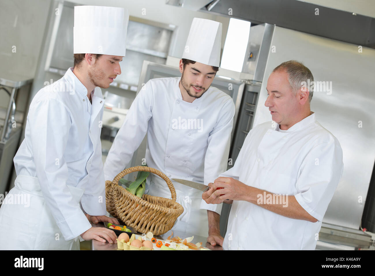 crew of positive professional cooks working at restaurant kitchen Stock ...