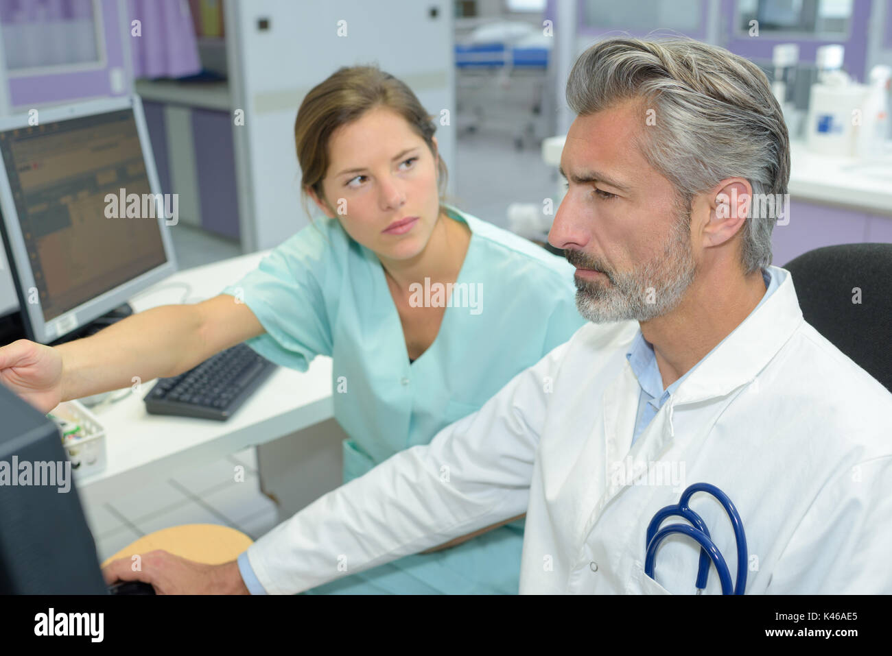 reading patient notes at nurses station Stock Photo - Alamy