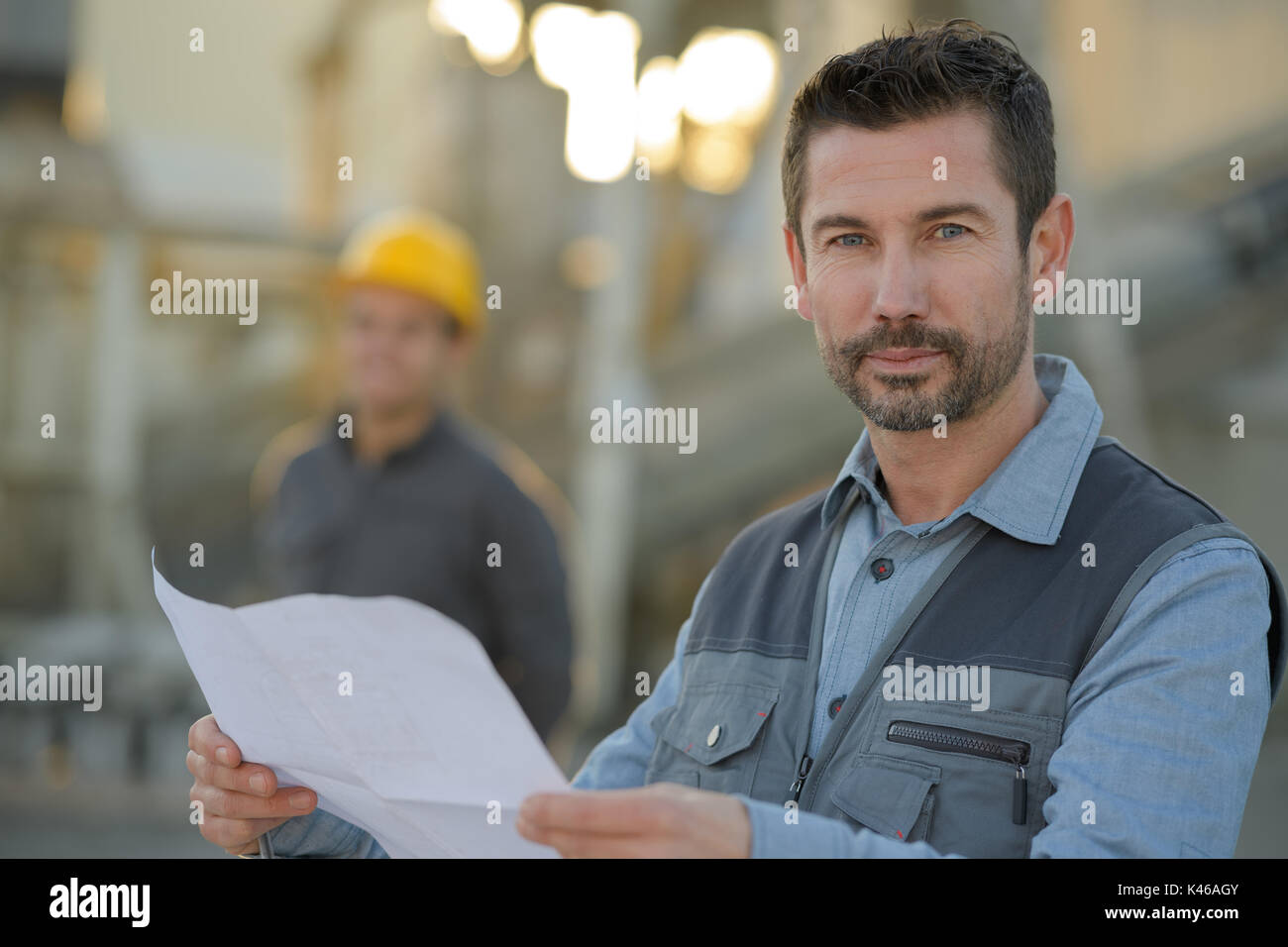 happy engineer in against construction site Stock Photo - Alamy