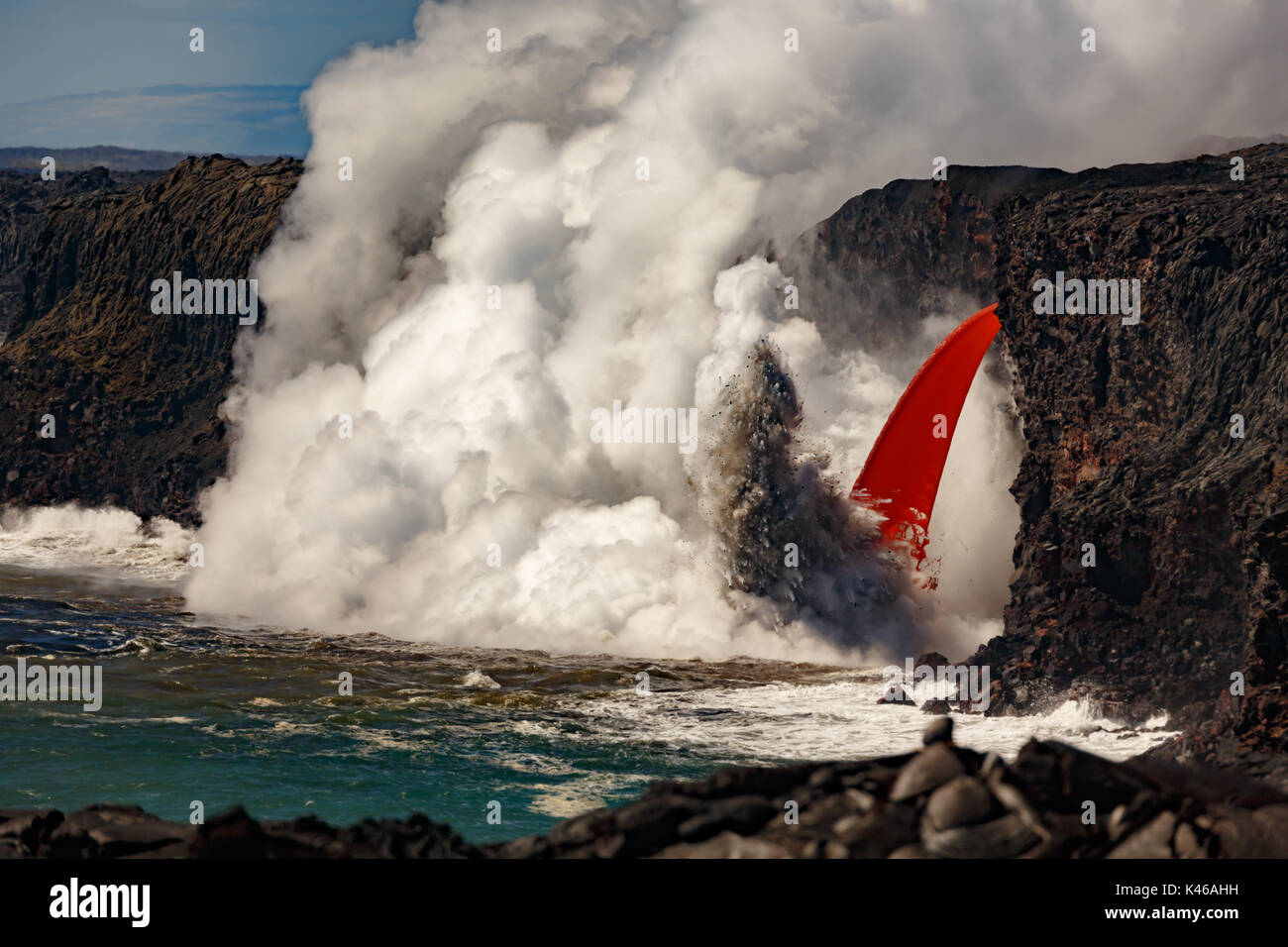 Aerial daytime view of top portion of waterfall shaped flow of red lava ...