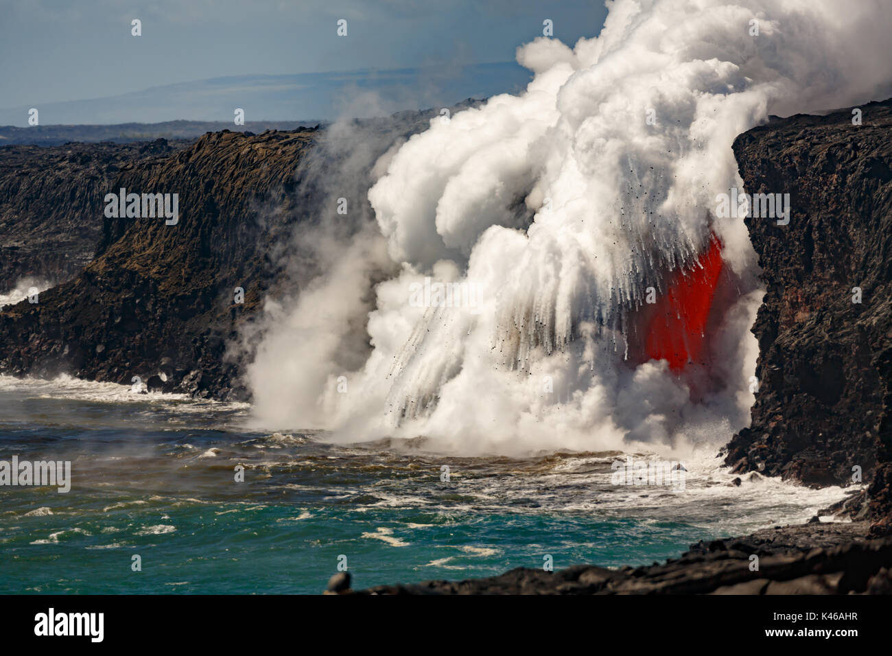 Aerial daytime view of top portion of waterfall shaped flow of red lava ...