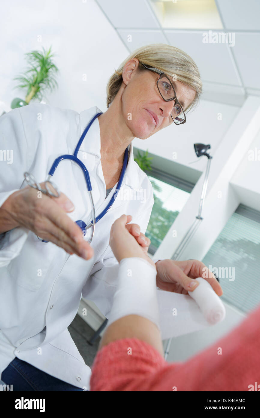female doctor bandaging womans injured arm Stock Photo - Alamy