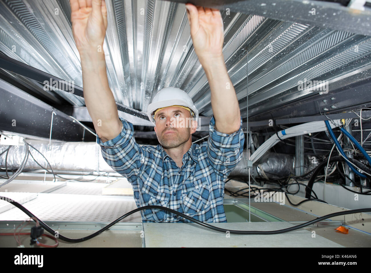 man making mount for electrical wires on ceiling Stock Photo - Alamy