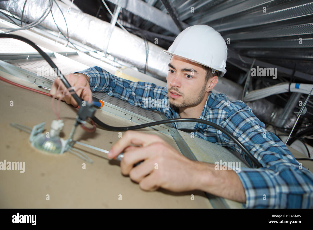 electrician fitting a led light to the ceiling Stock Photo - Alamy