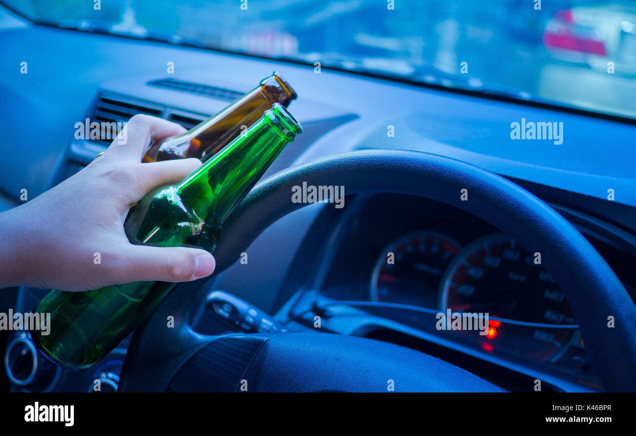 Man drink beer while driving car. Driving in a state of intoxication ...