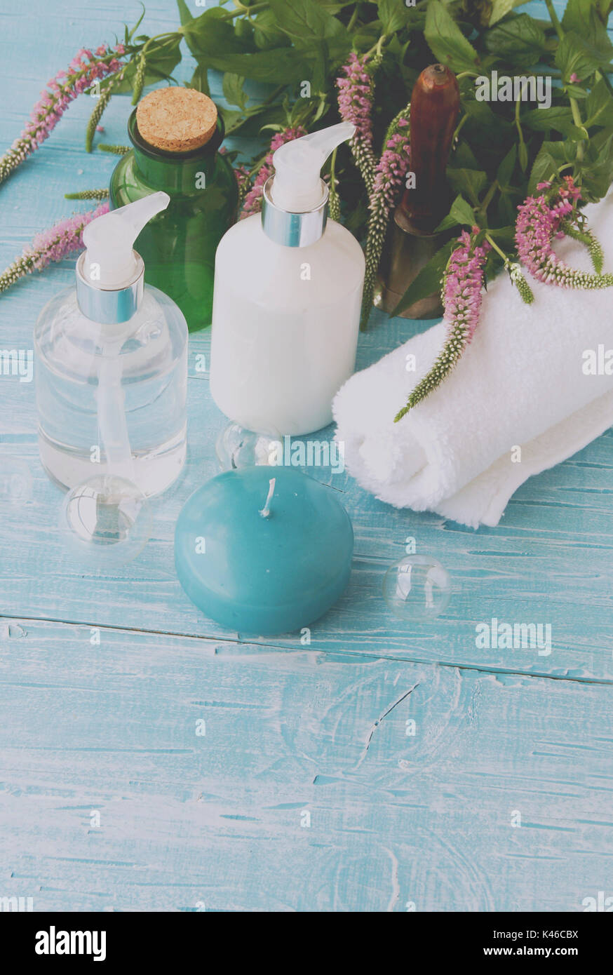 White flowers lying on a blue wooden board with shell and candle Spa ...