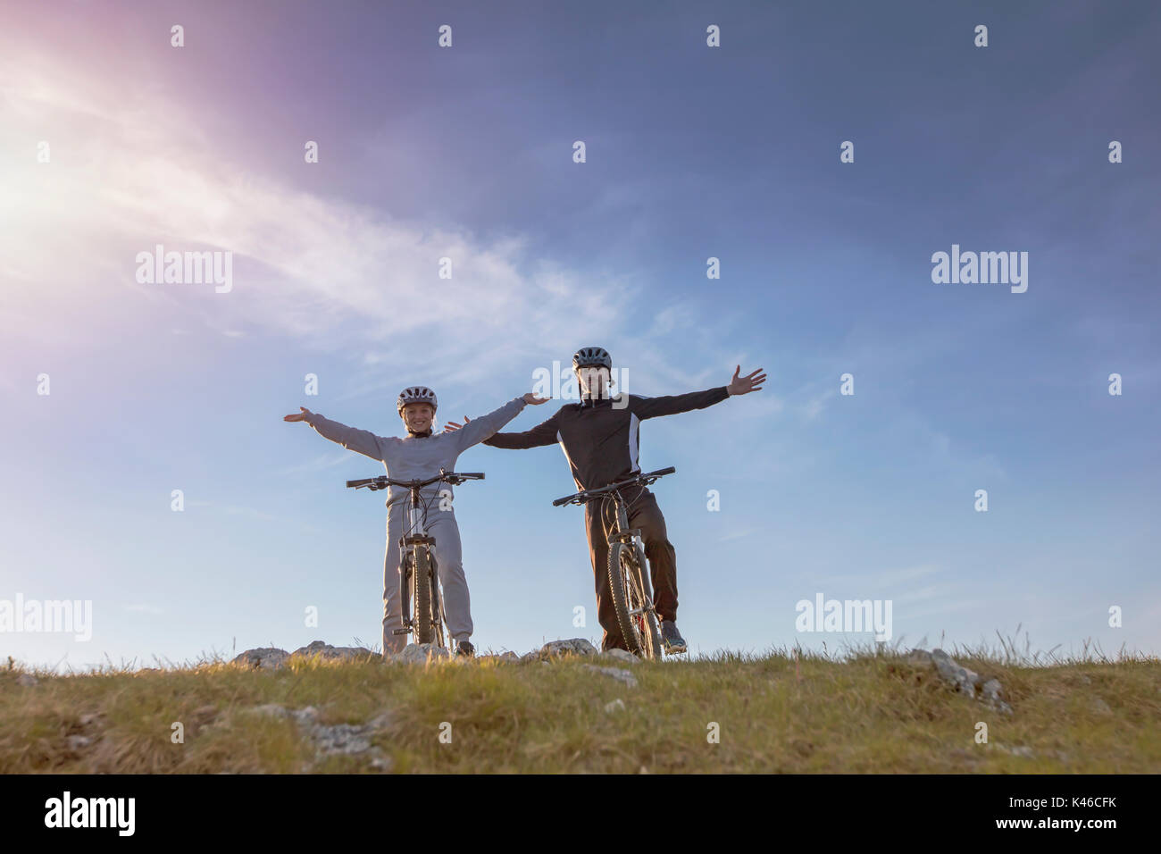 Biker couple with mountain bike pointing in distance at countryside ...
