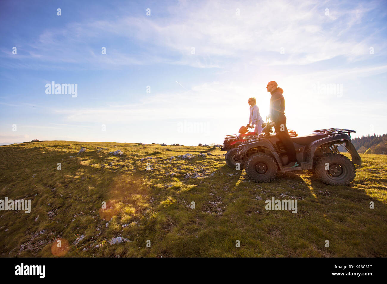Couple driving off-road with quad bike or ATV Stock Photo - Alamy