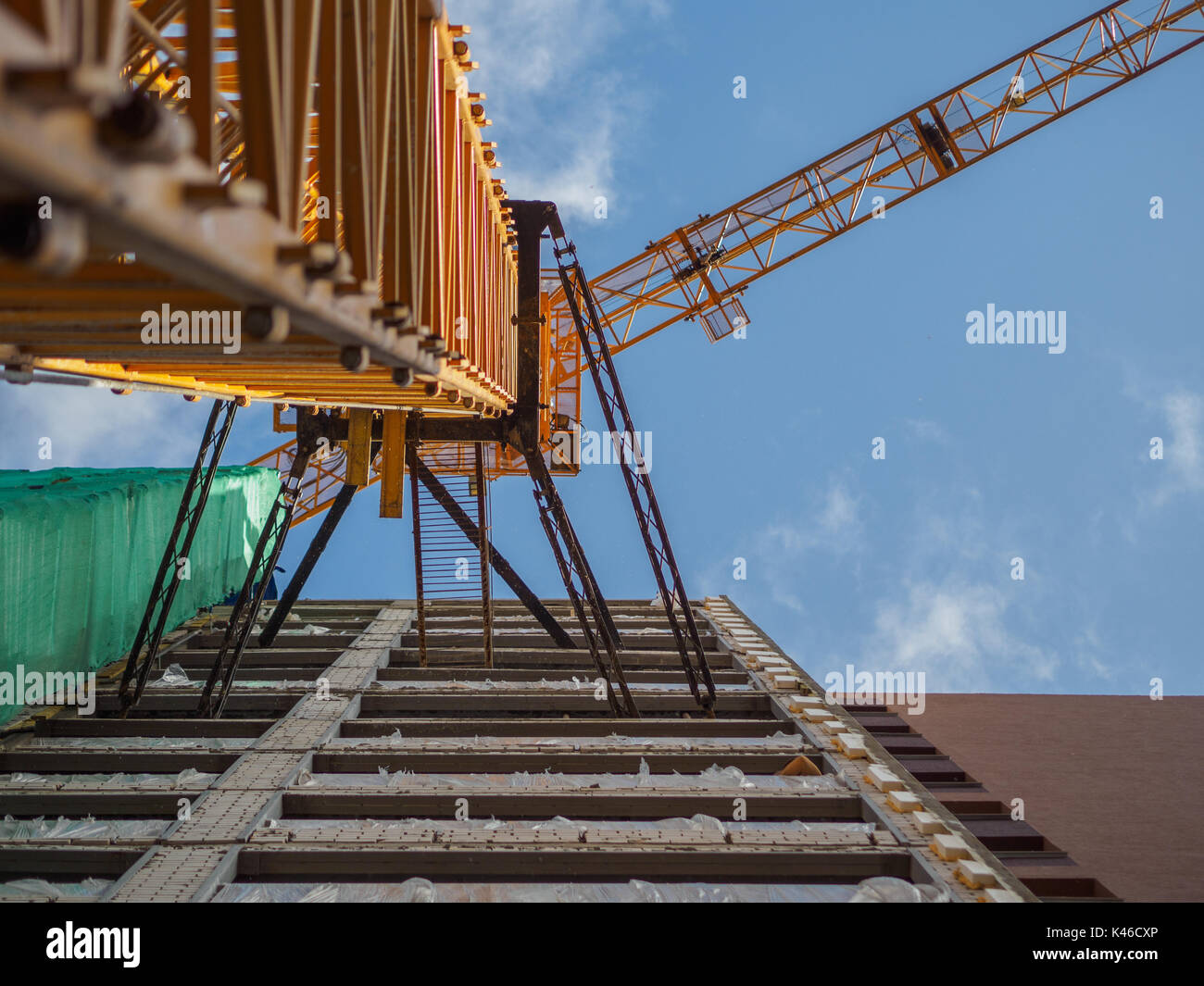 Yellow crane attached to building under construction Stock Photo - Alamy