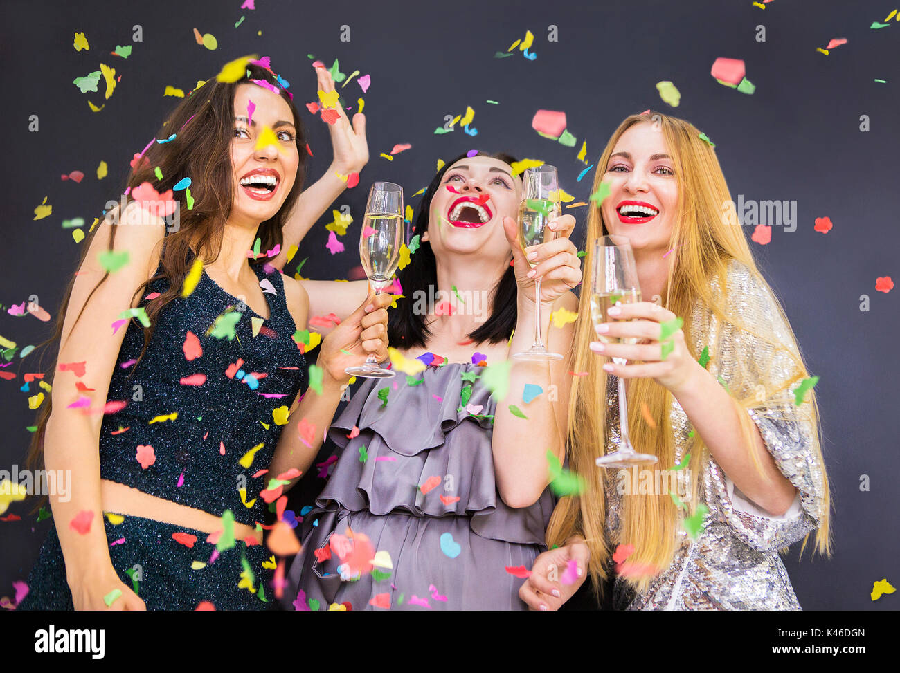 Three young smiling woman having fun an drinking champagne. Celebration ...