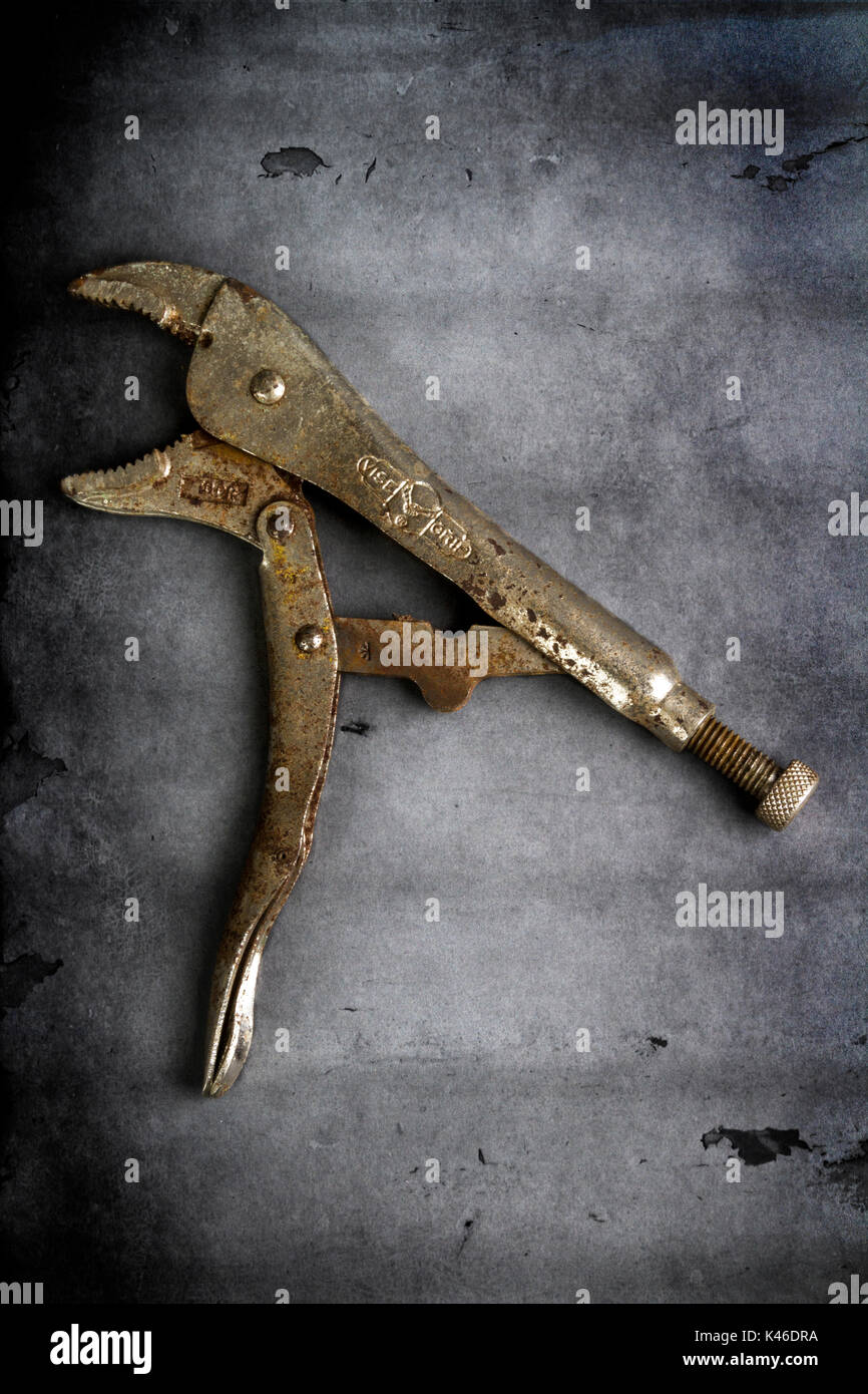 Old rusty mole grips on a metal background Stock Photo - Alamy