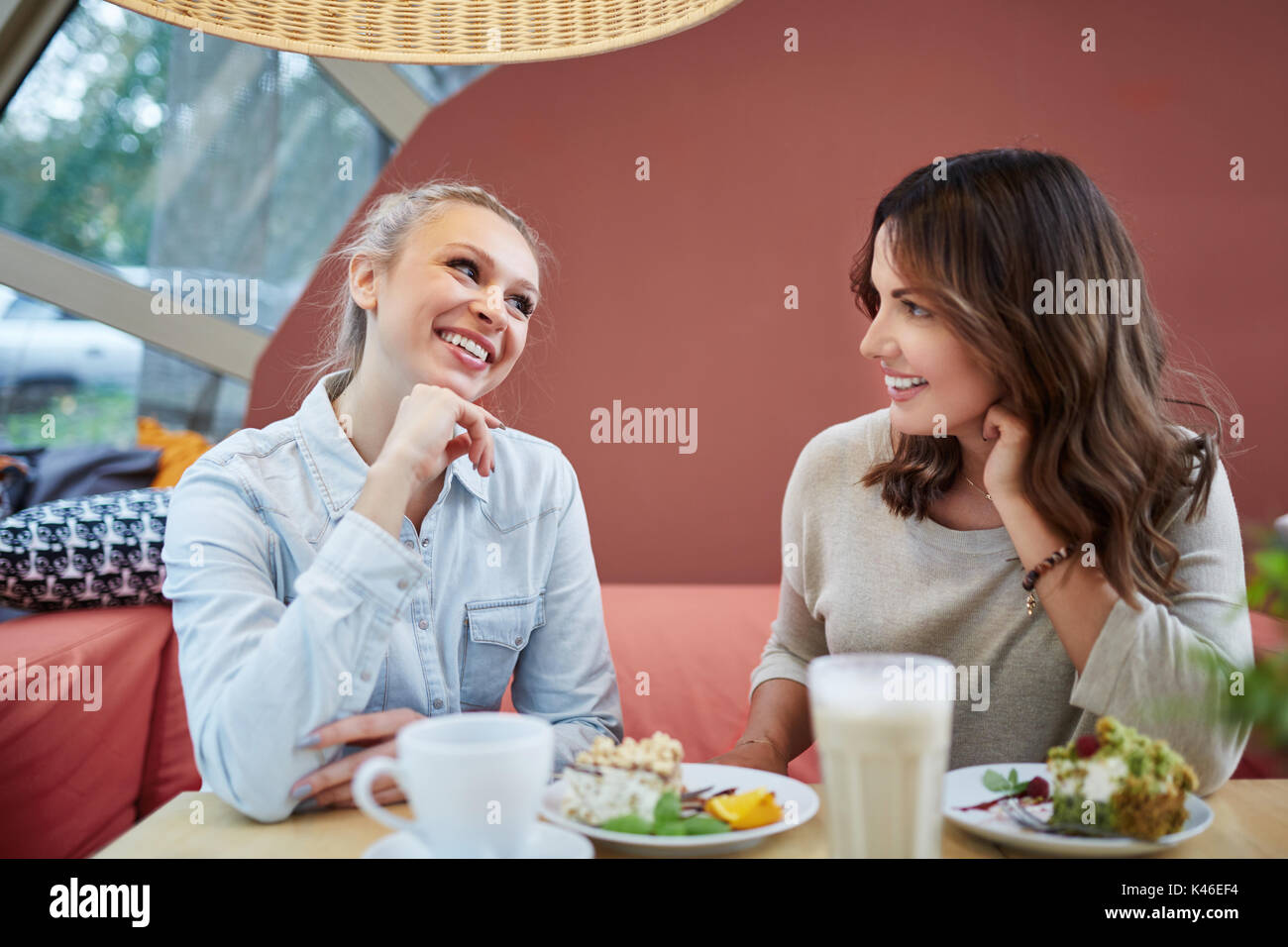 Portrait of two women friends talking over a coffee and dessert Stock ...