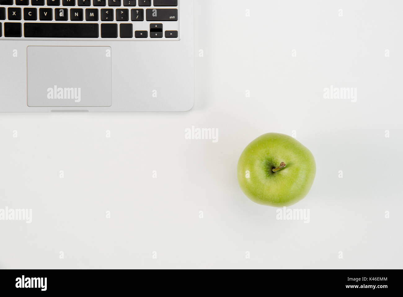Top view of open laptop and fresh green apple isolated on grey ...